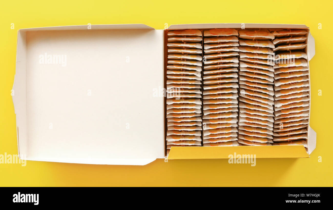 Top down view, box full of tea bags on yellow board Stock Photo - Alamy