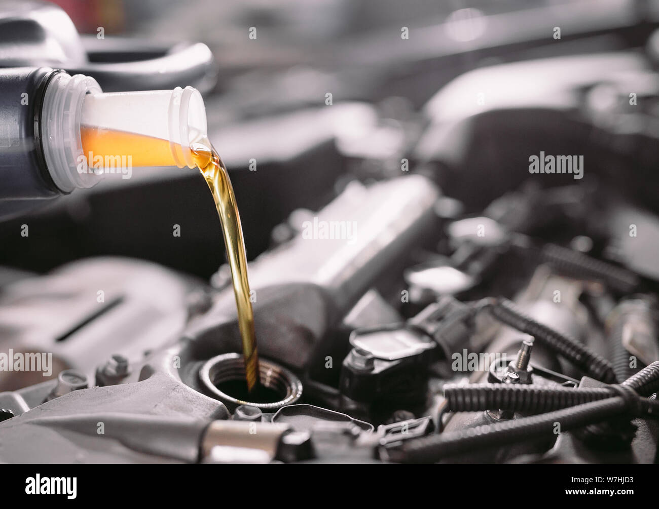 Motor oil pouring to car engine. A service station Stock Photo - Alamy