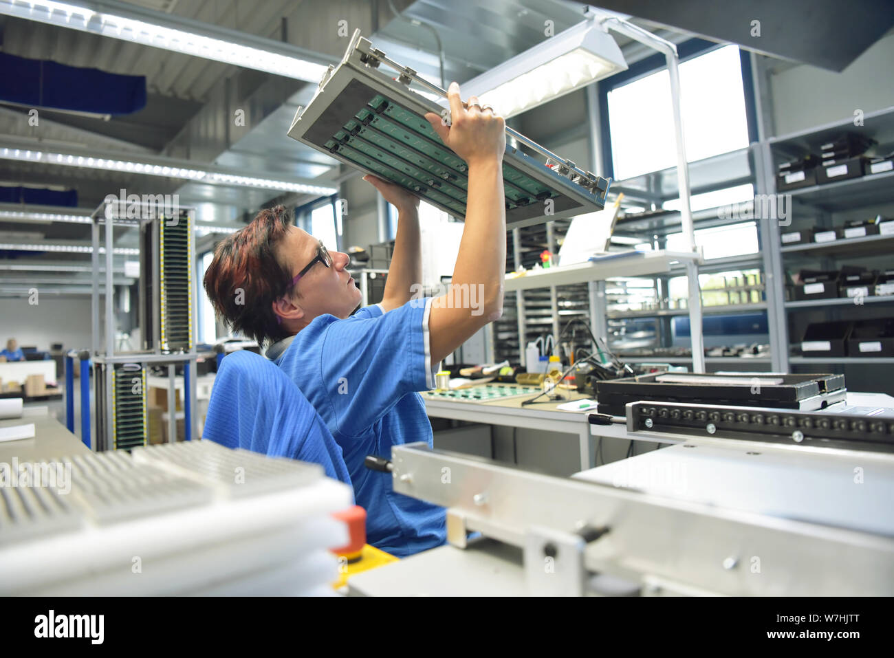 quality control - woman checking motherboard - working in the ...