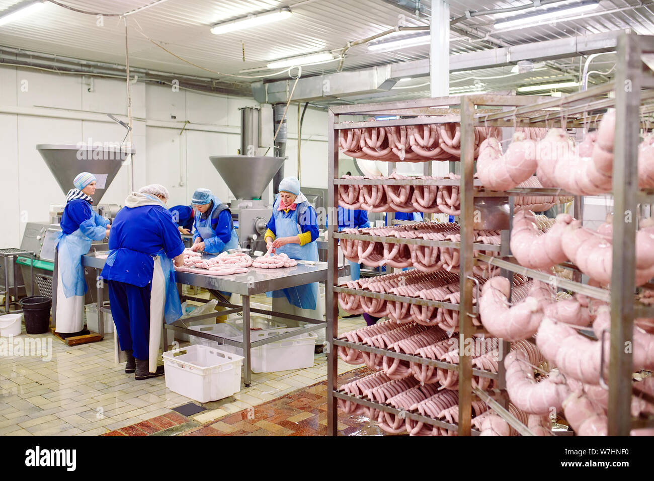 Butchers processing sausages at the meat factory Stock Photo - Alamy