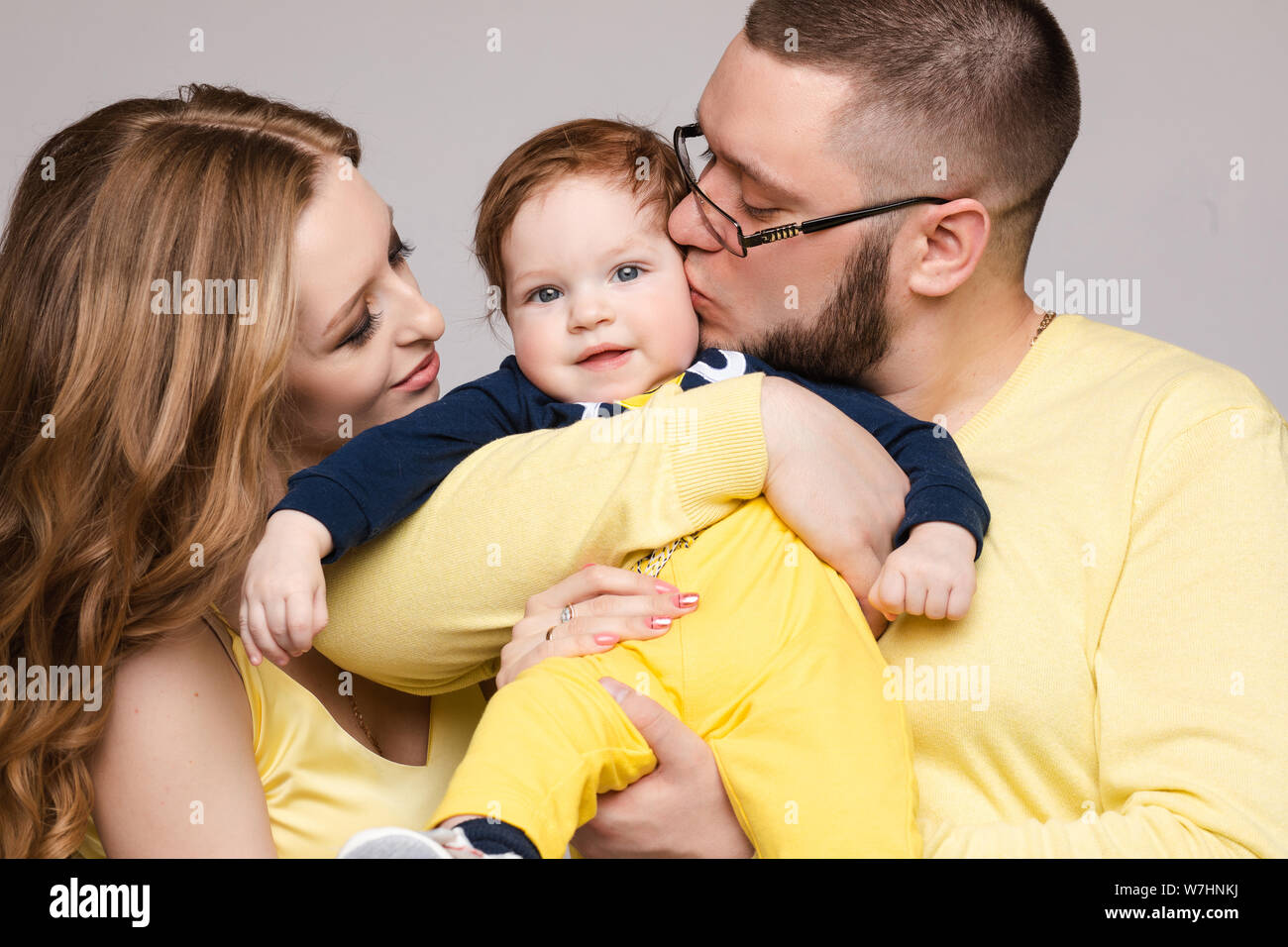 Family in yellow outfit posing on isolated background Stock Photo - Alamy