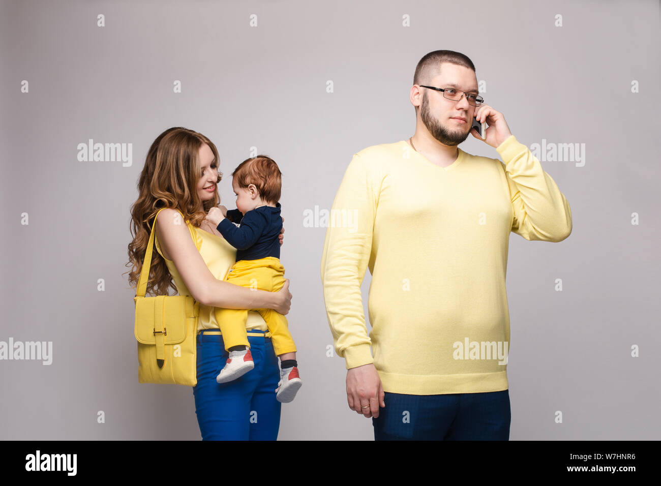 Busy father talking by phone while mother playing with kid Stock Photo ...