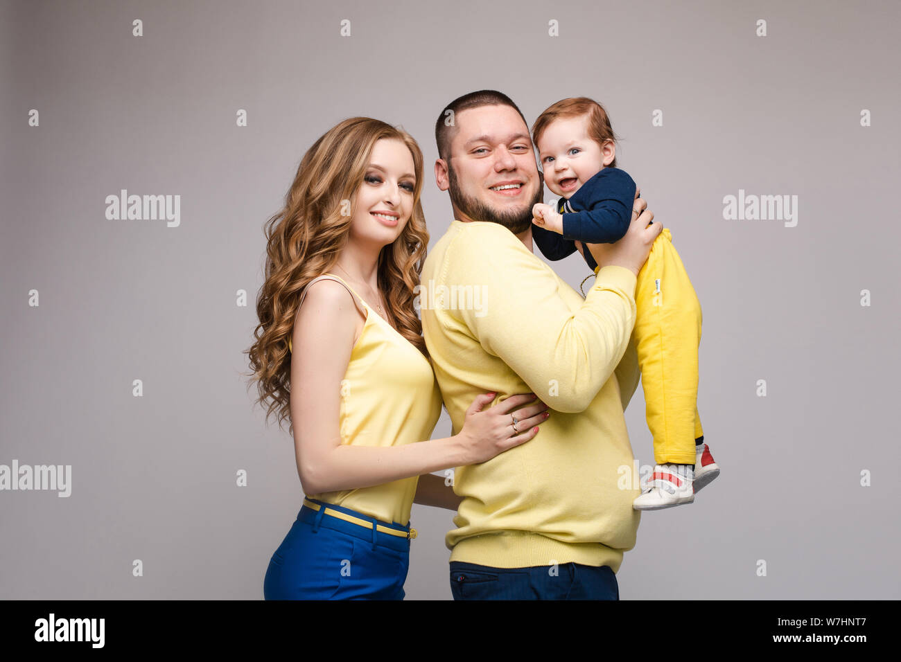 Family in yellow outfit posing on isolated background Stock Photo - Alamy