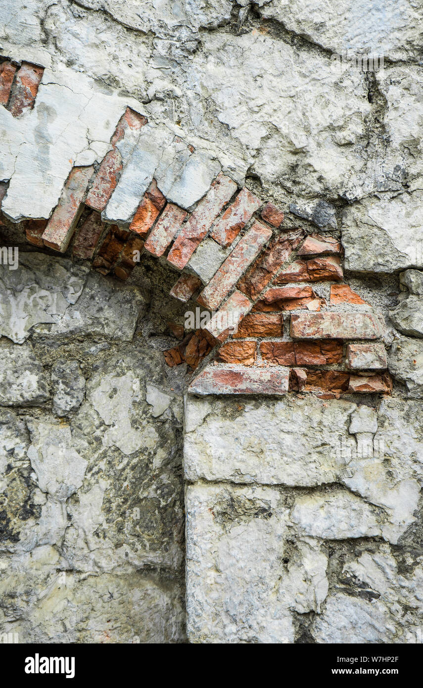 Part of the old gray stone wall with scattered orange bricks on the ...