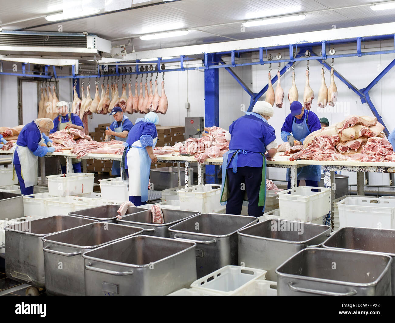 Cutting meat in slaughterhouse at the meat manufacturing Stock Photo ...