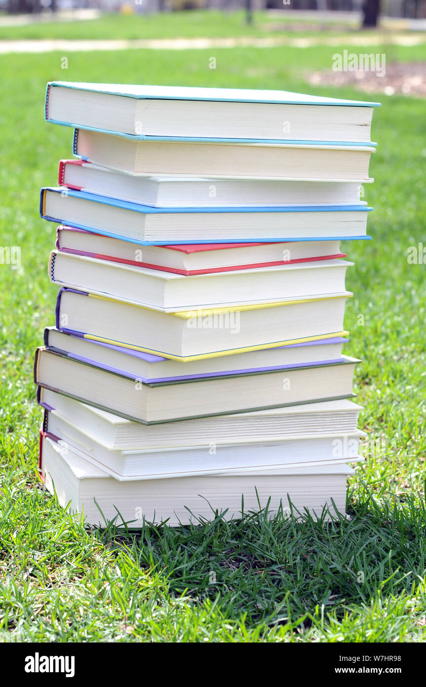 a pile of colorful books on lawn in campus Stock Photo - Alamy