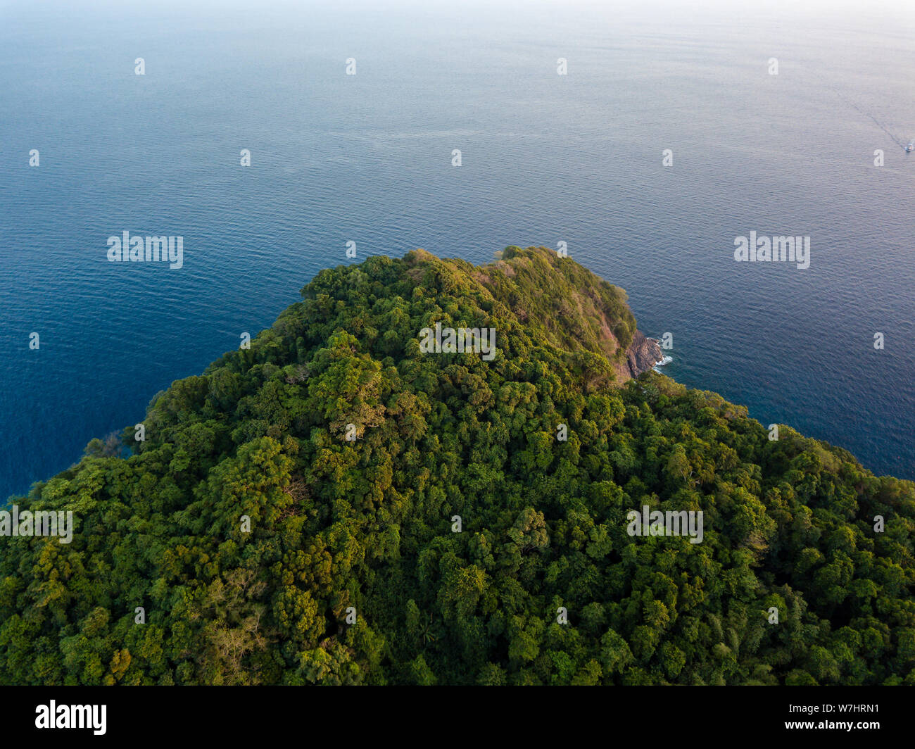 Aerial drone view of sunset over a jungle covered remote tropical ...