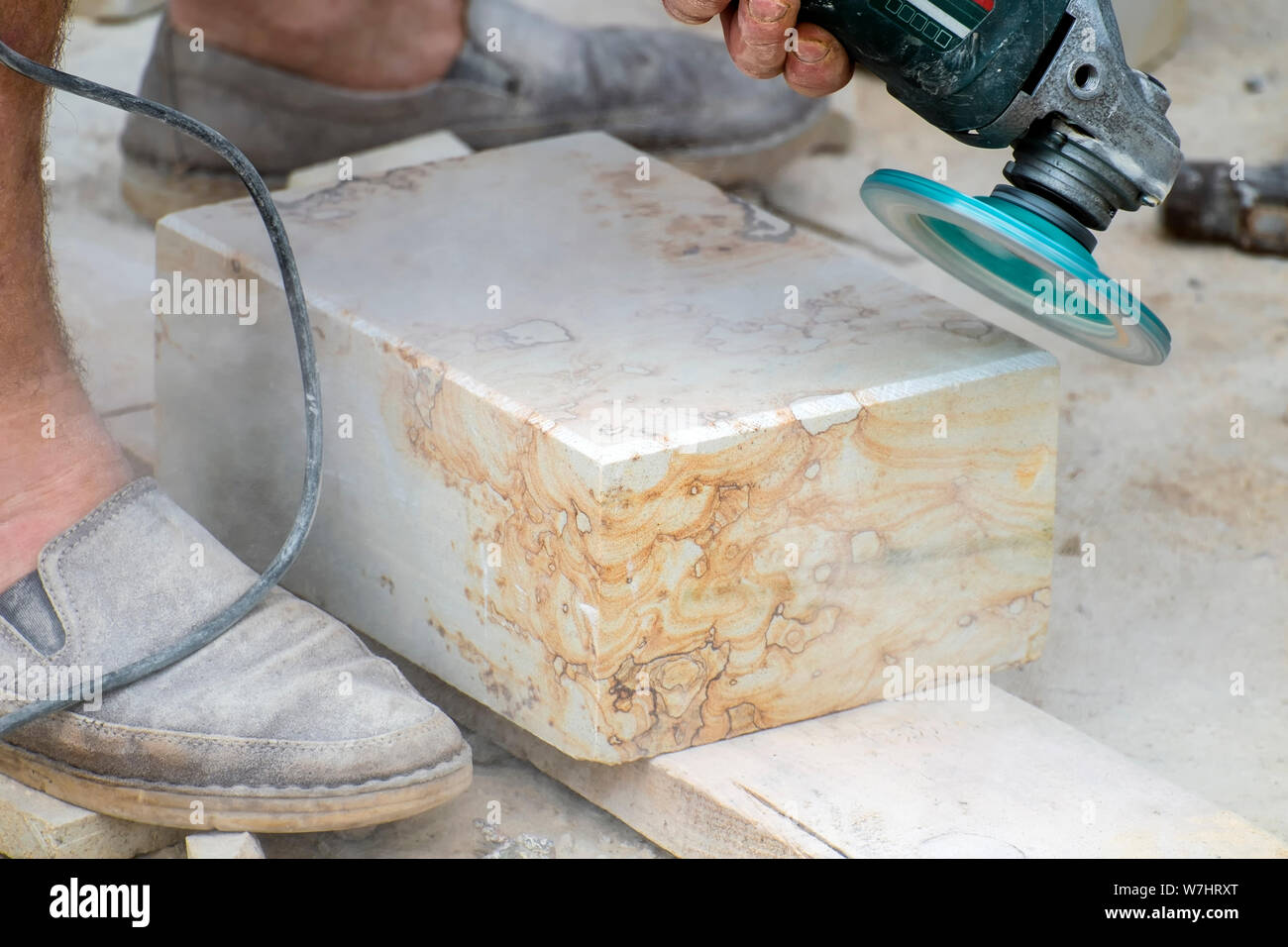 Angle grinder makes chamfer on antique travertine Stock Photo - Alamy