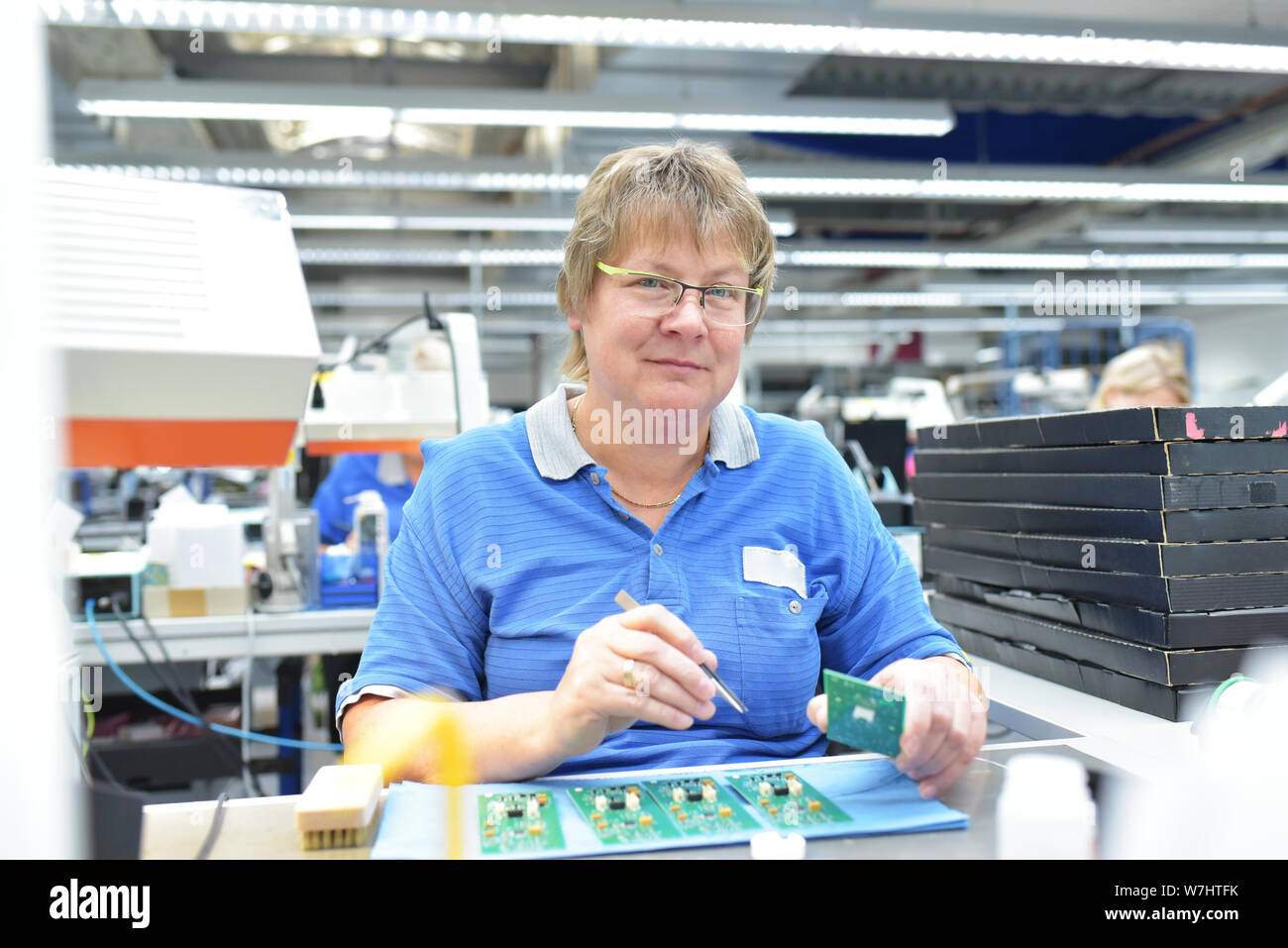 friendly woman working in a microelectronics manufacturing factory ...
