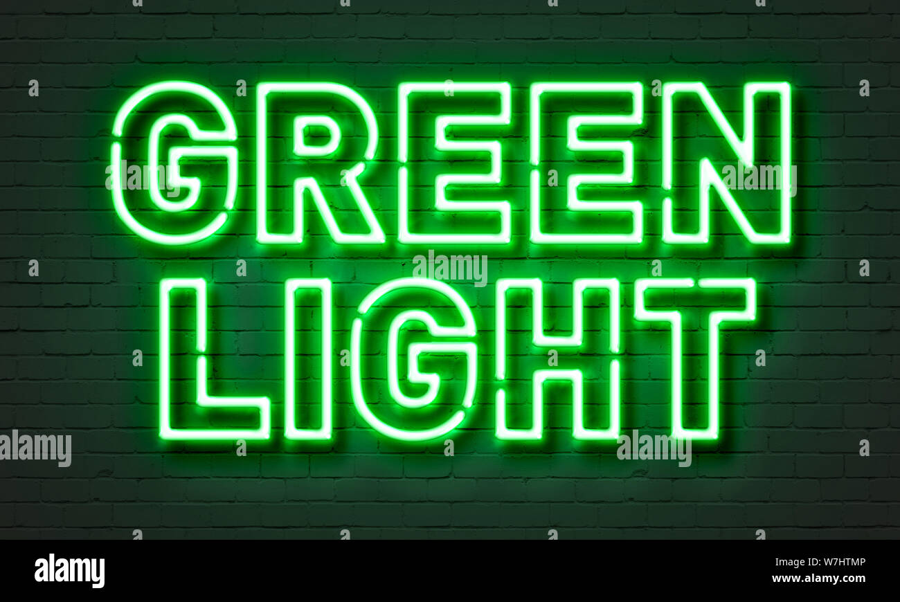 Green light neon sign on brick wall background Stock Photo - Alamy