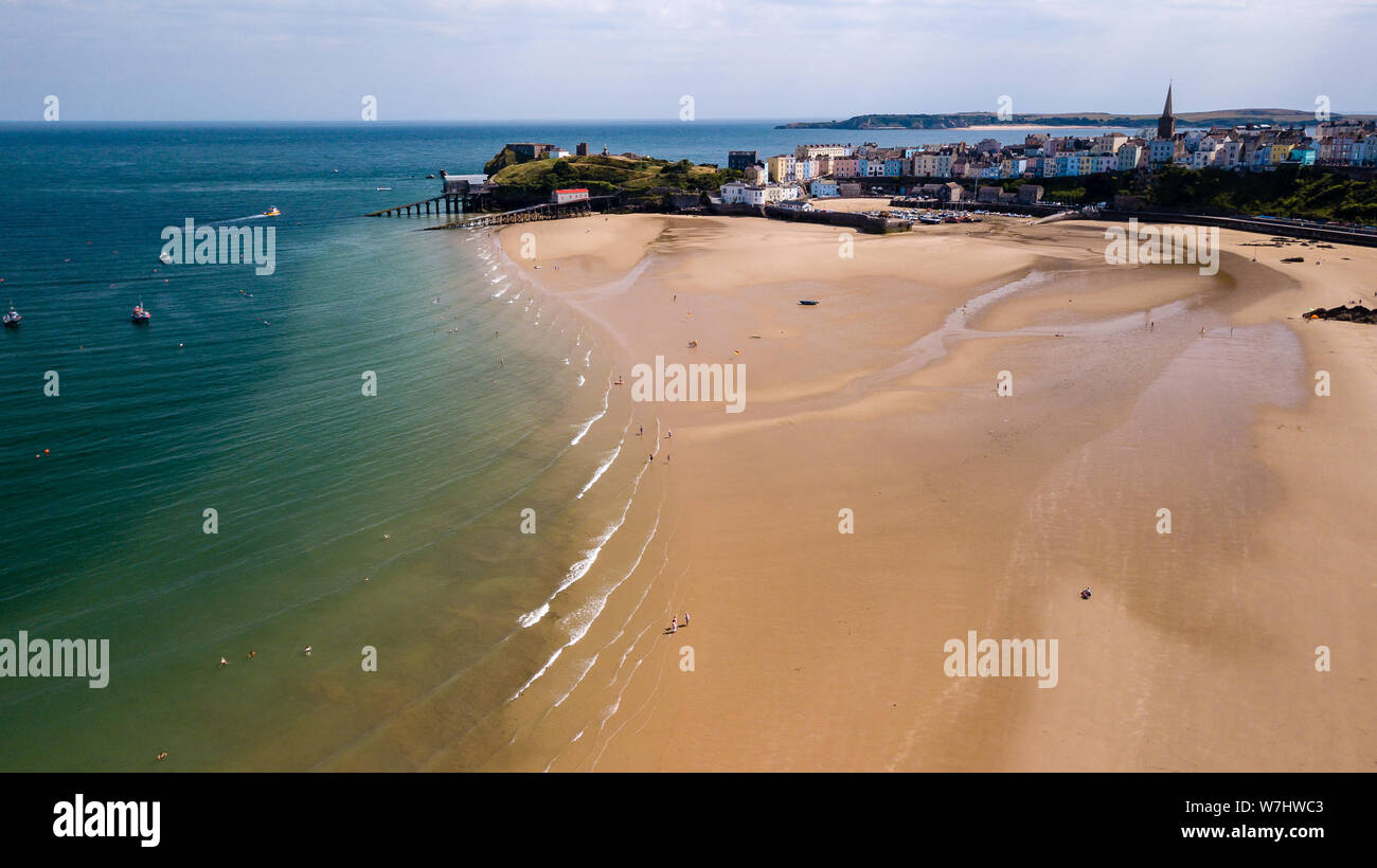 Boats stranded at low tide on a huge, sandy beach at a colorful ...