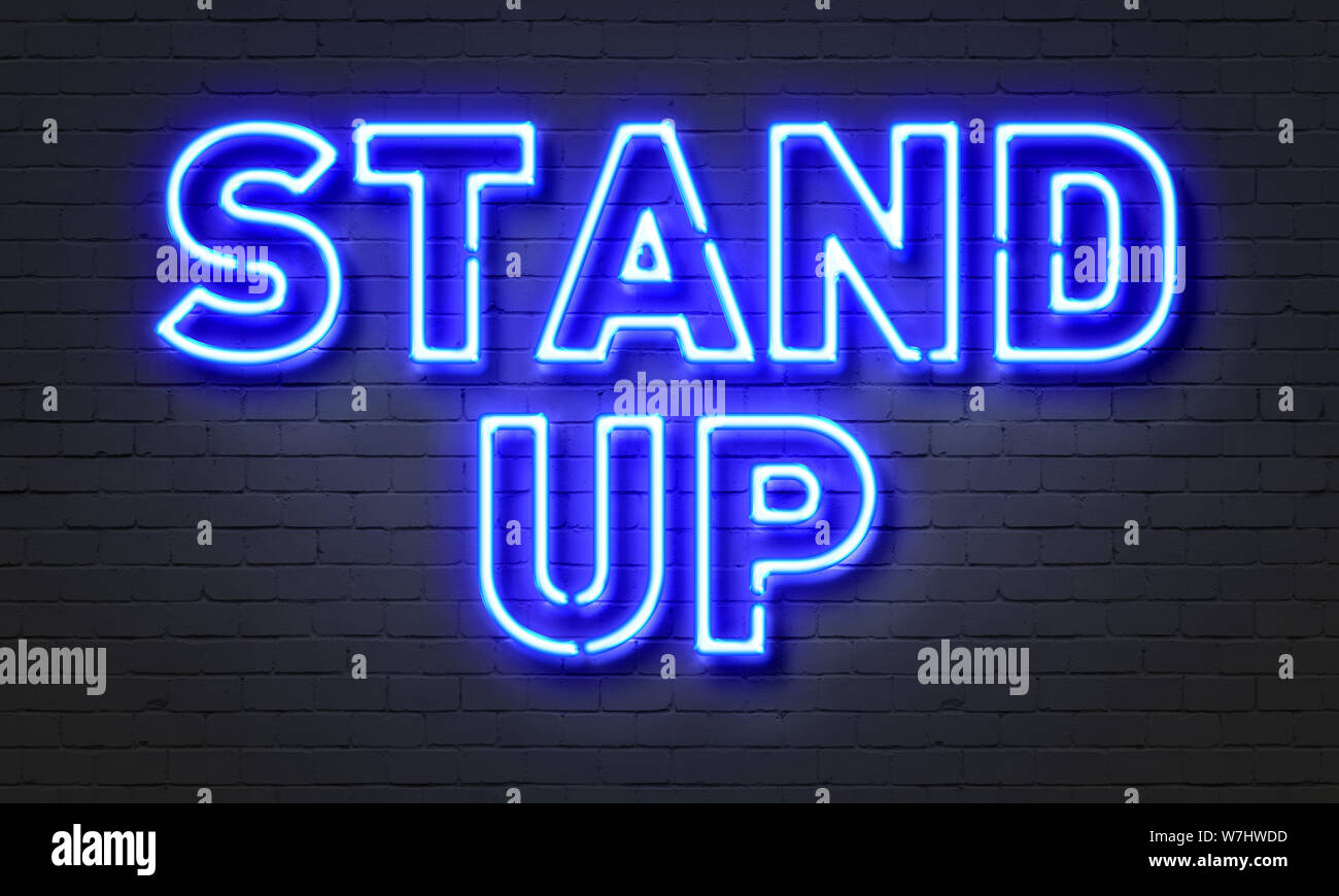 Stand up neon sign on brick wall background Stock Photo - Alamy