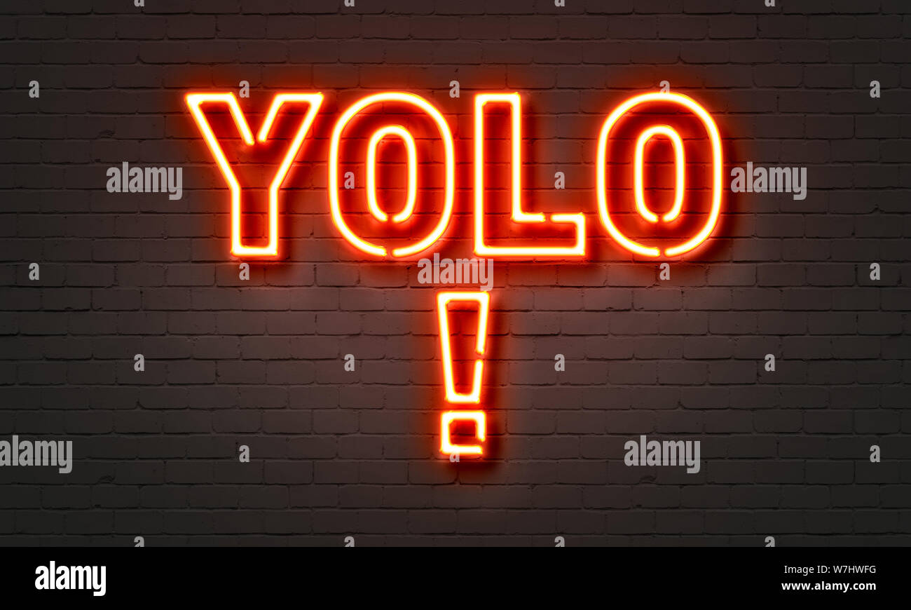 YOLO neon sign on brick wall background Stock Photo - Alamy