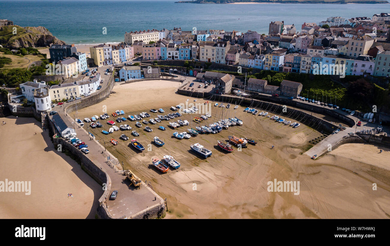Aerial drone view of fishing boats beached at low tide in a harbour at ...