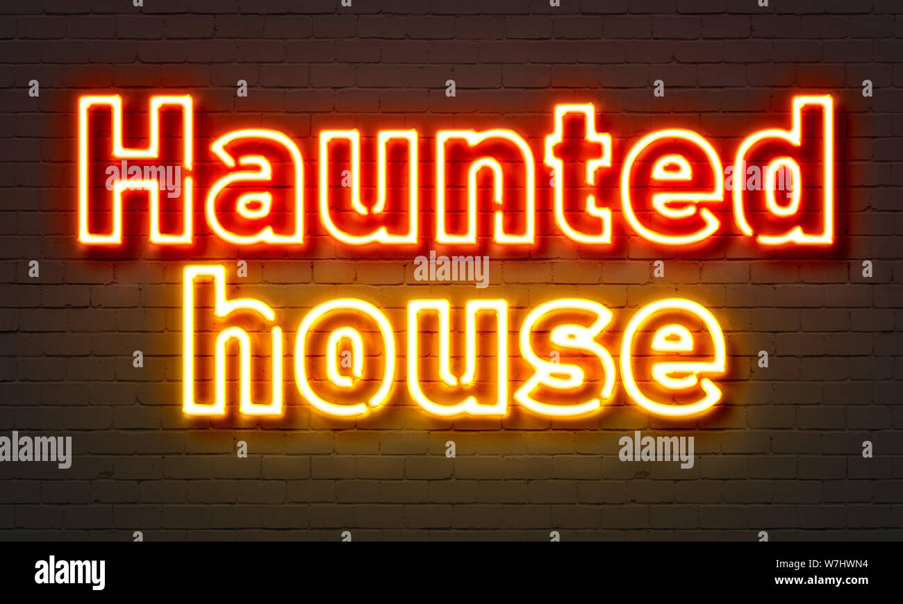 Haunted house neon sign on brick wall background Stock Photo - Alamy