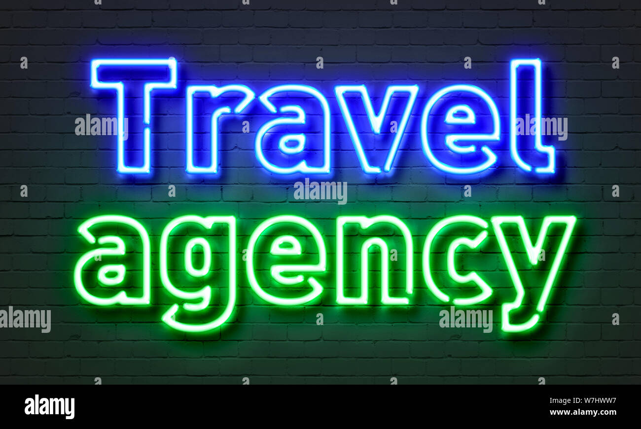 Travel agency neon sign on brick wall background Stock Photo - Alamy