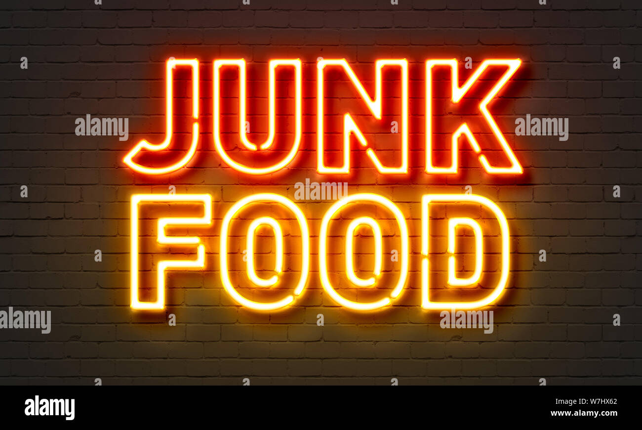 Junk food neon sign on brick wall background Stock Photo - Alamy