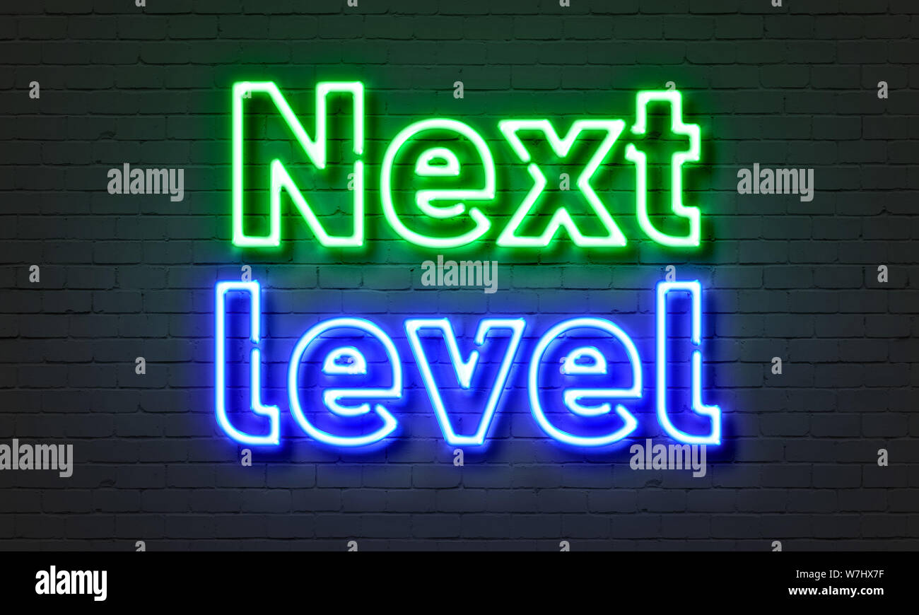 Next level neon sign on brick wall background Stock Photo - Alamy
