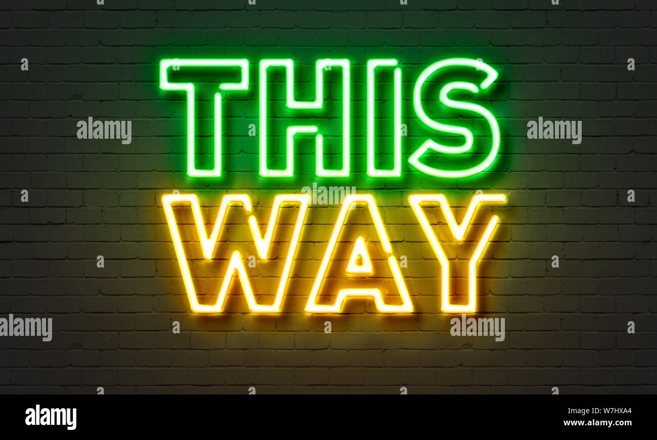 This way neon sign on brick wall background Stock Photo - Alamy