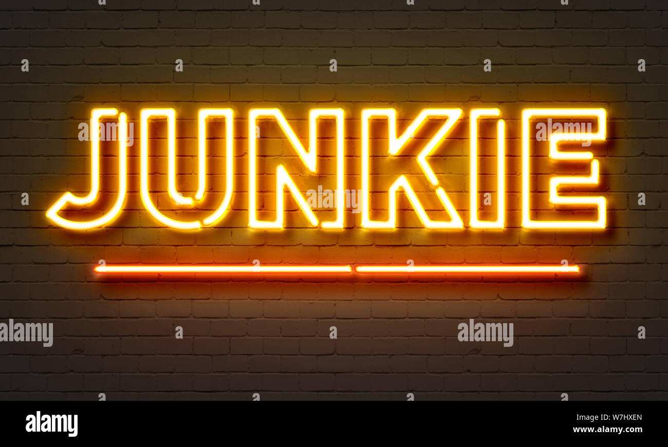 Junkie neon sign on brick wall background Stock Photo - Alamy