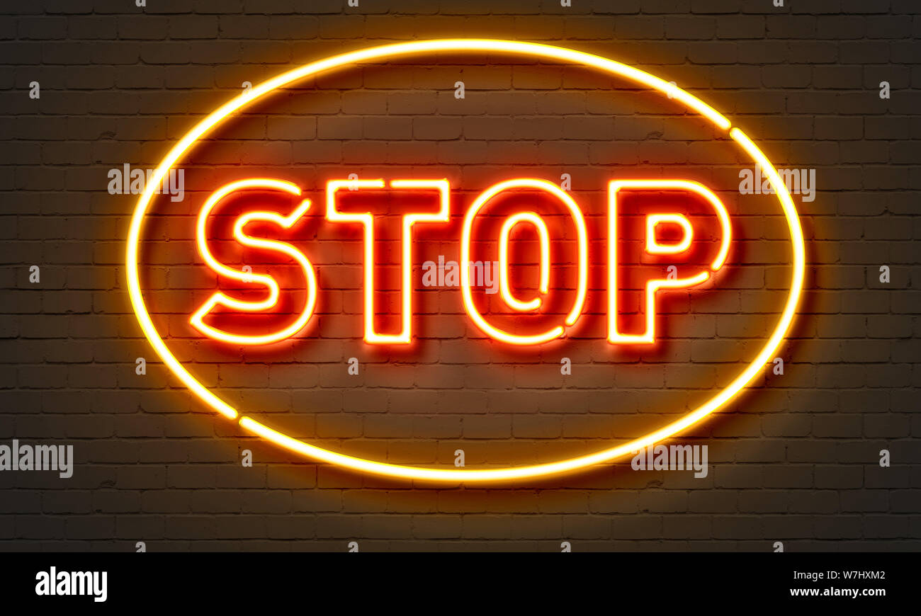 Stop neon sign on brick wall background Stock Photo - Alamy