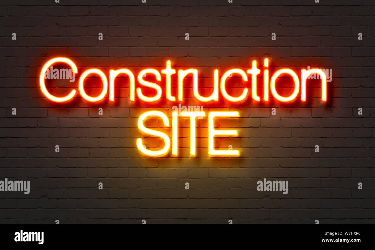 Construction site neon sign on brick wall background Stock Photo - Alamy