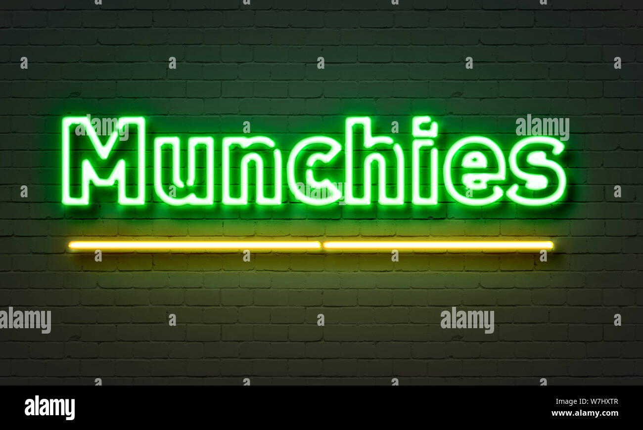 Munchies neon sign on brick wall background Stock Photo - Alamy