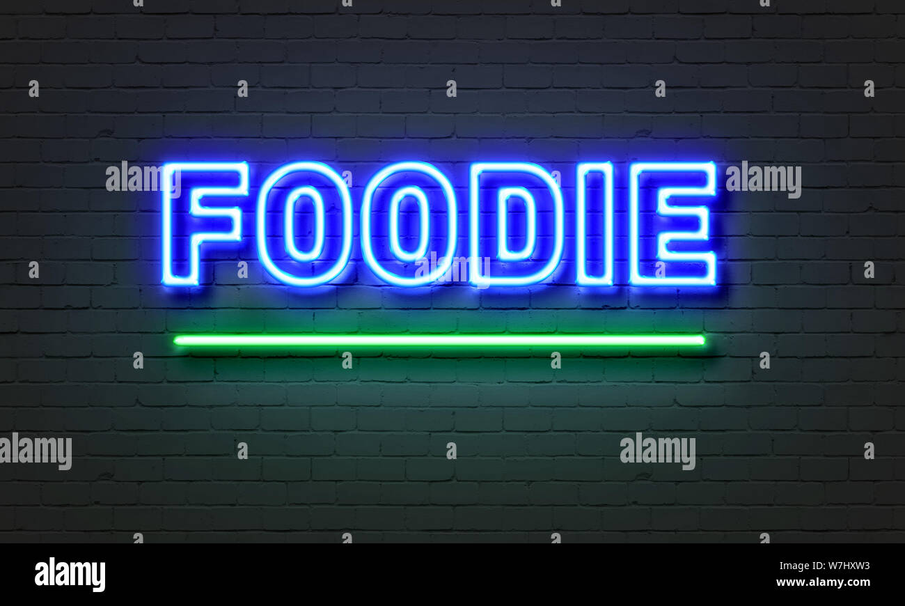 Foodie neon sign on brick wall background Stock Photo - Alamy