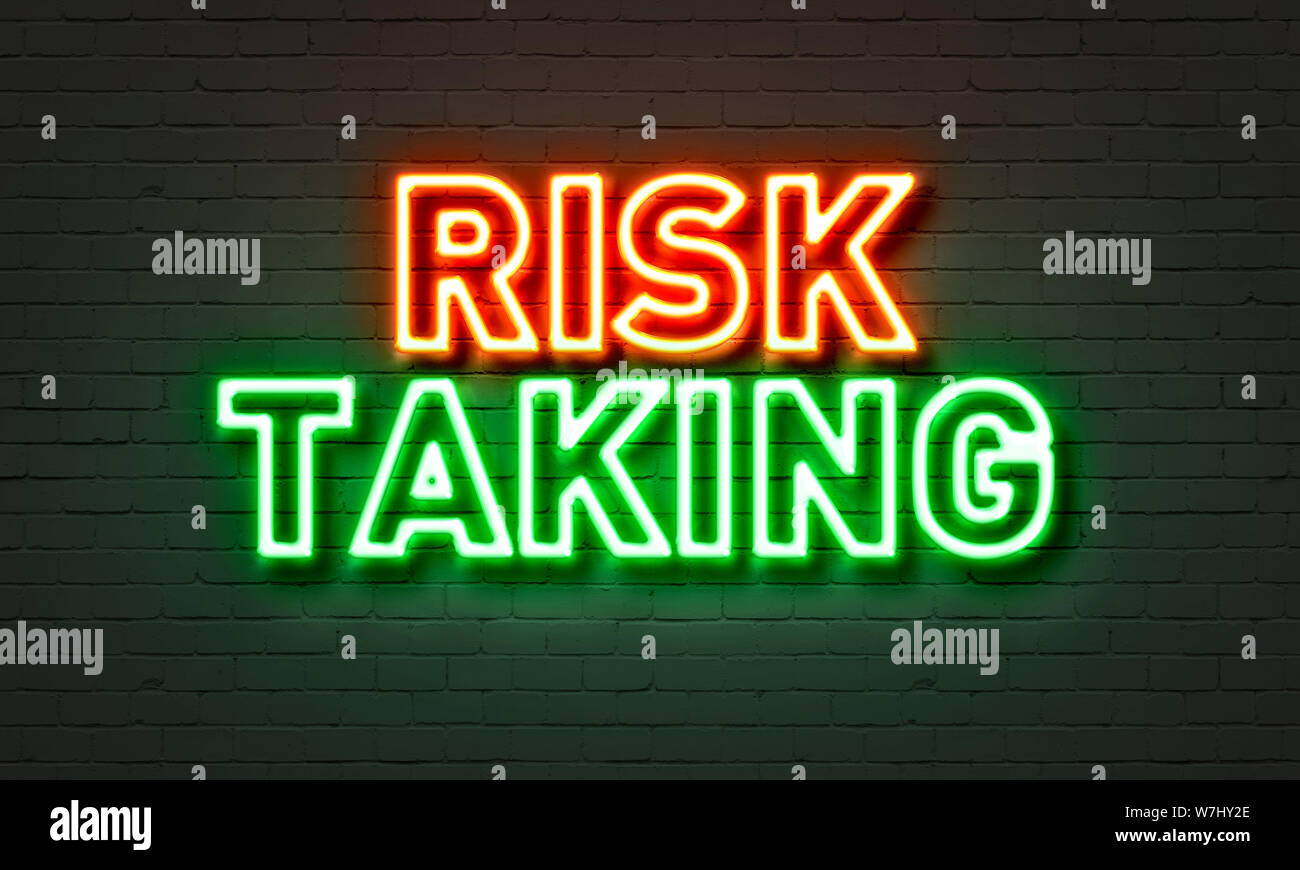 Risk taking neon sign on brick wall background Stock Photo - Alamy