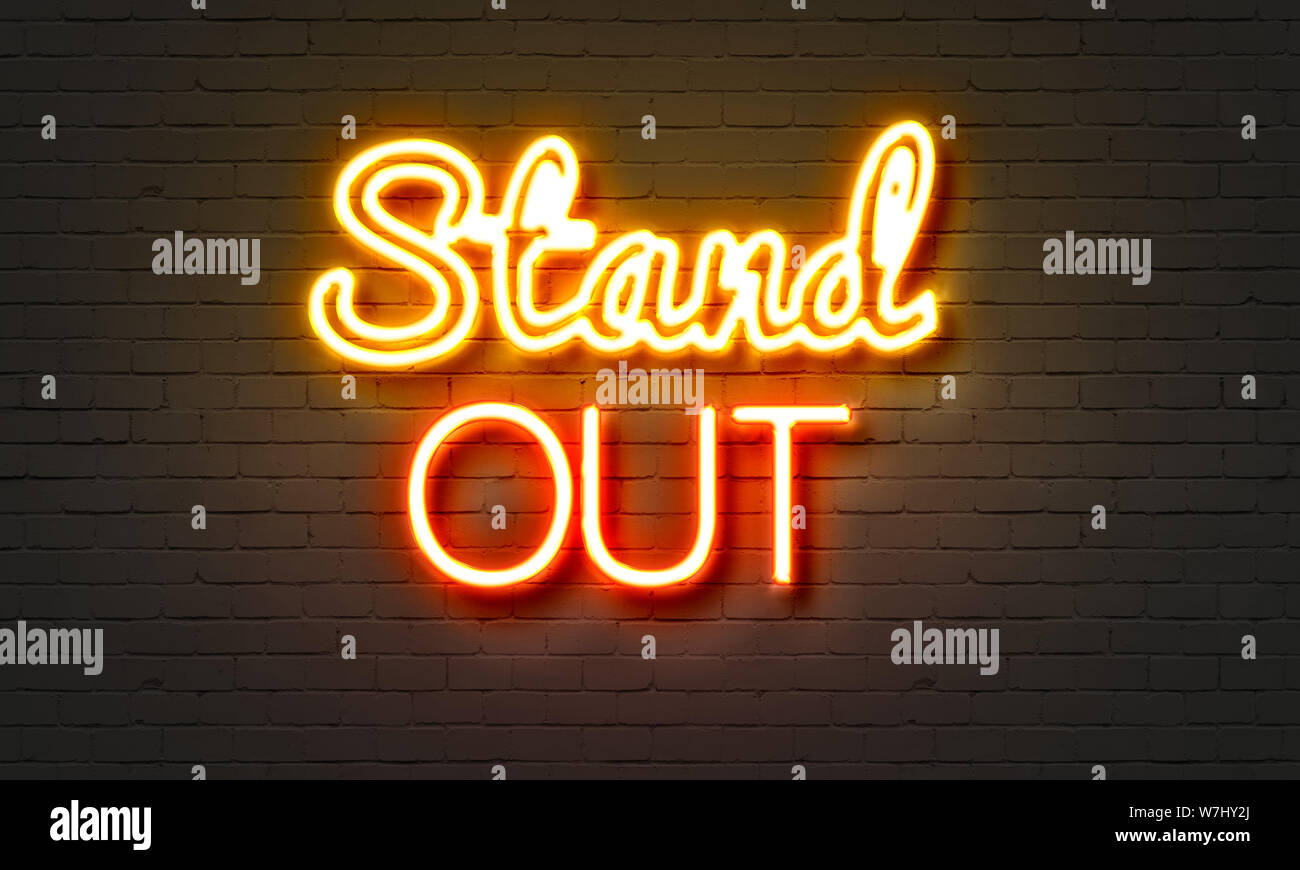 Stand out neon sign on brick wall background Stock Photo - Alamy