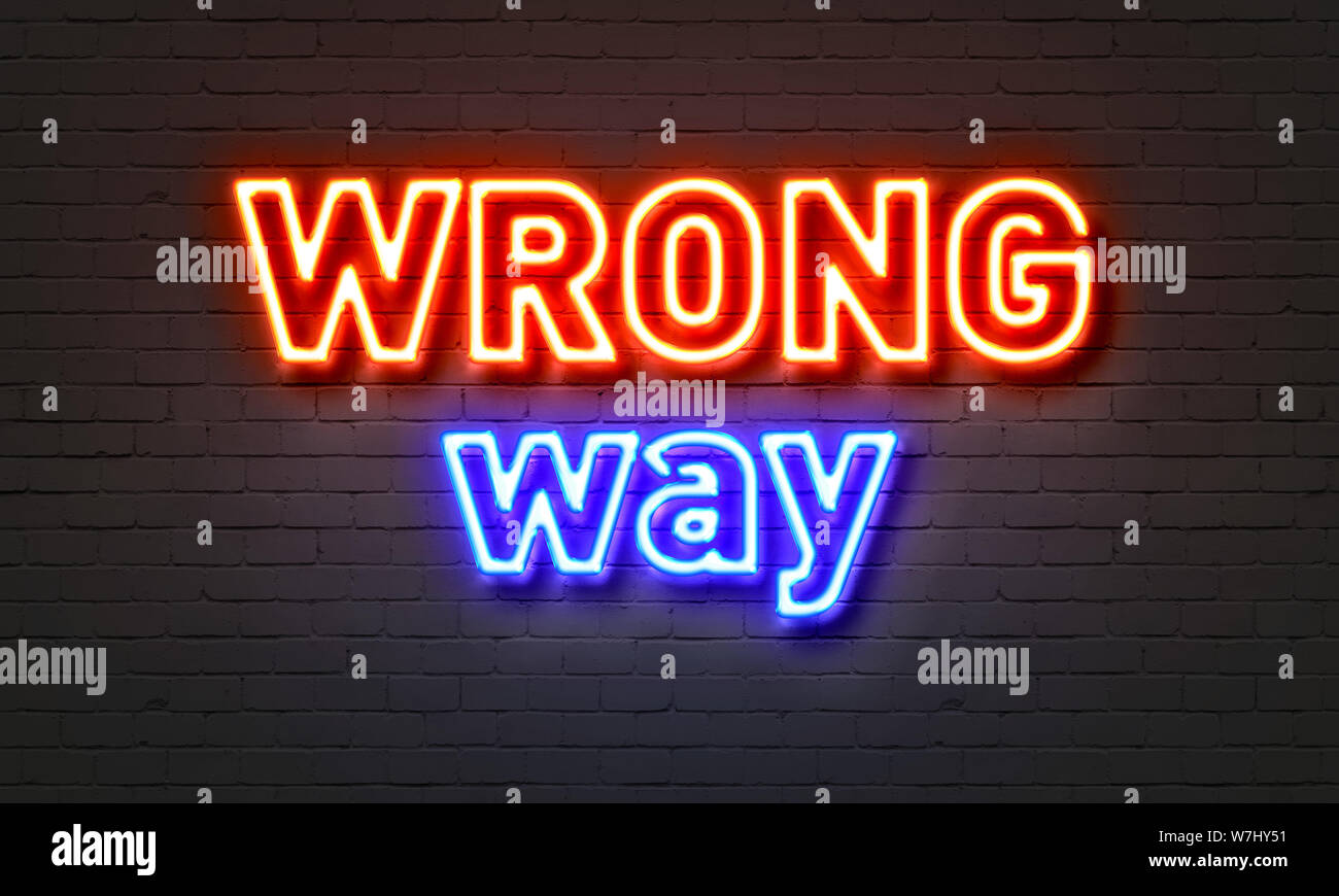 Wrong way neon sign on brick wall background Stock Photo - Alamy