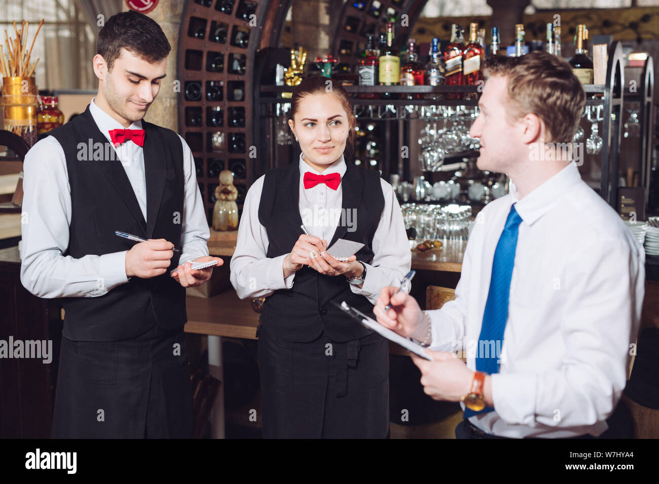Manager's briefing with the waiters. Restaurant manager and his staff ...