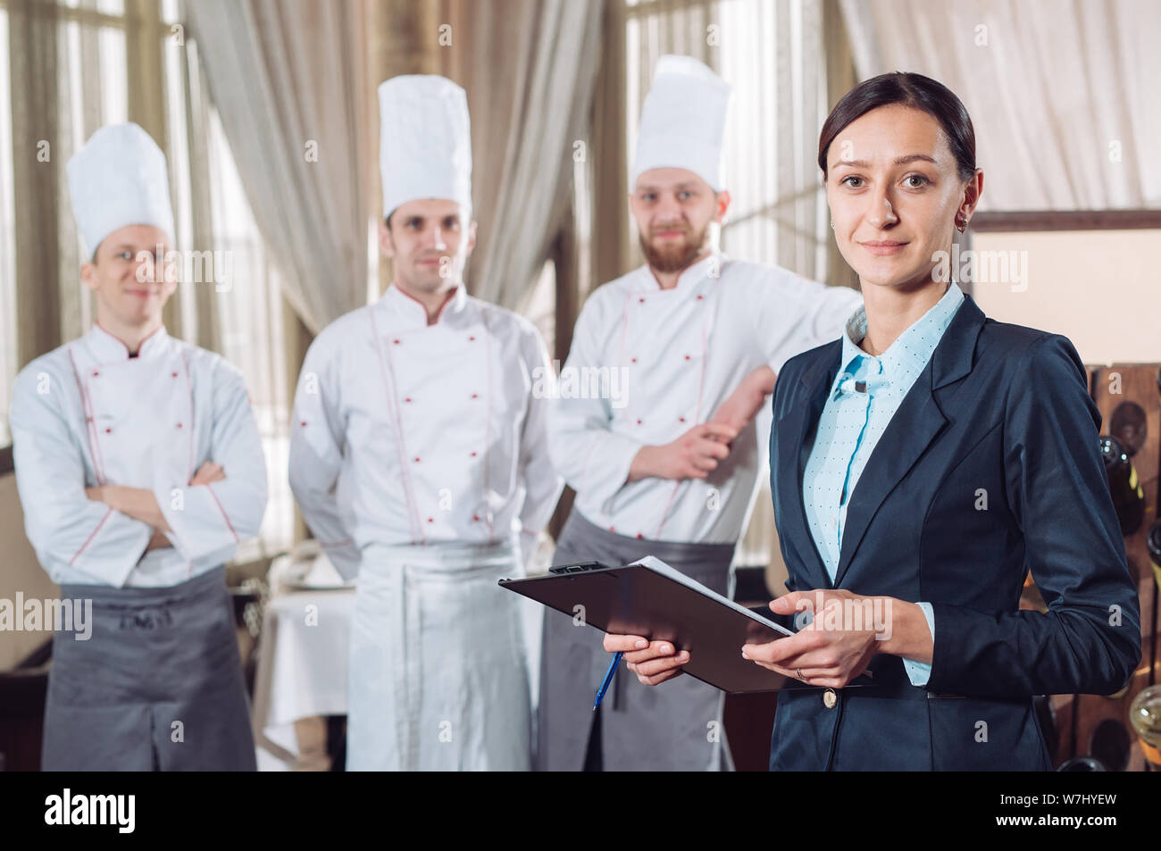 restaurant manager and his staff in kitchen. interacting to head chef ...