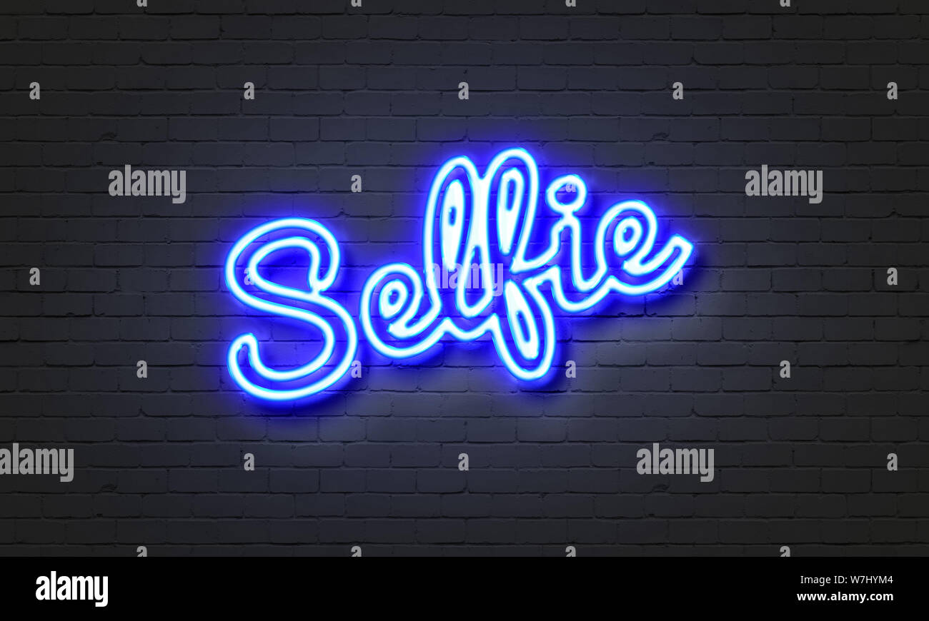 Selfie neon sign on brick wall background Stock Photo - Alamy