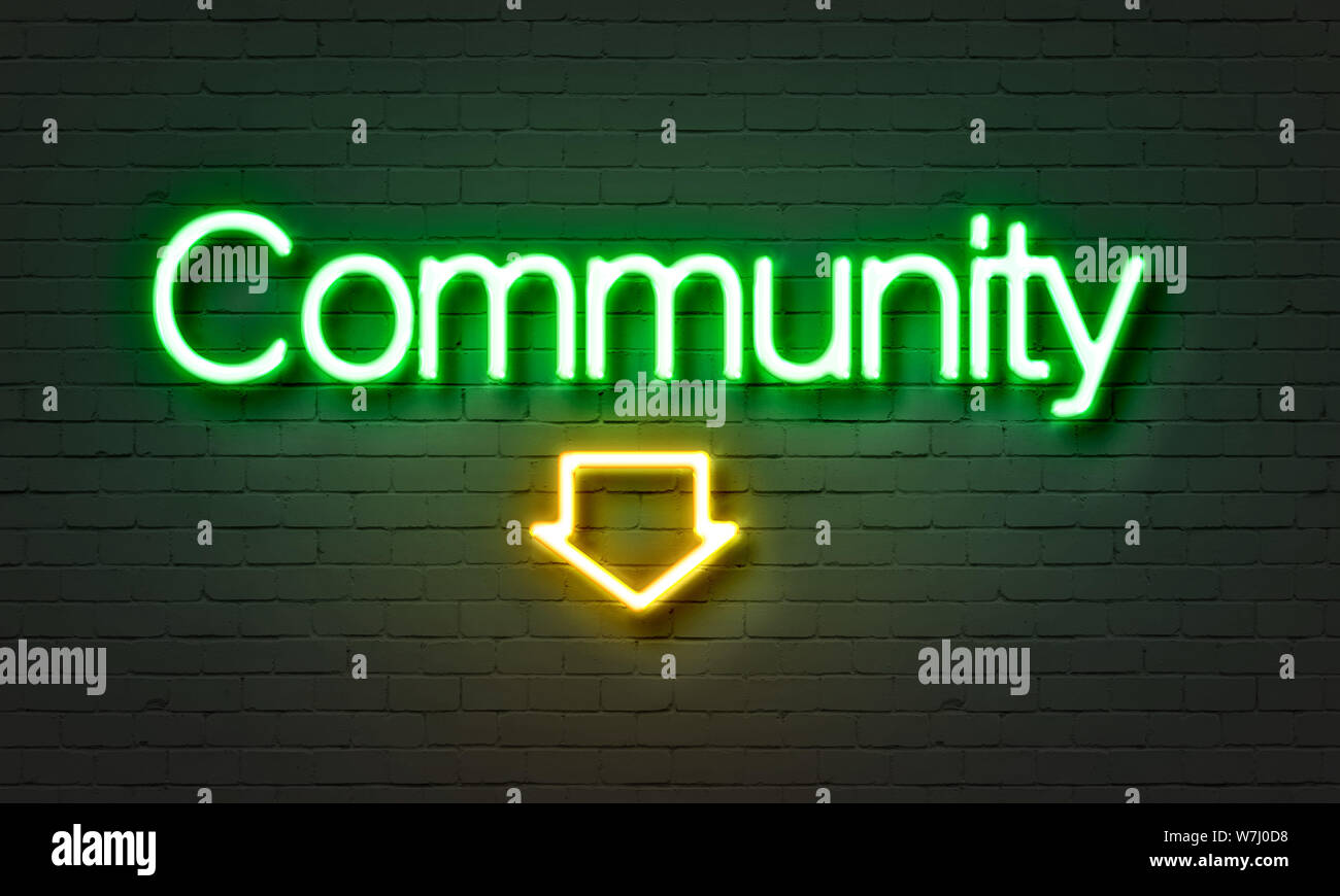 Community neon sign on brick wall background Stock Photo - Alamy