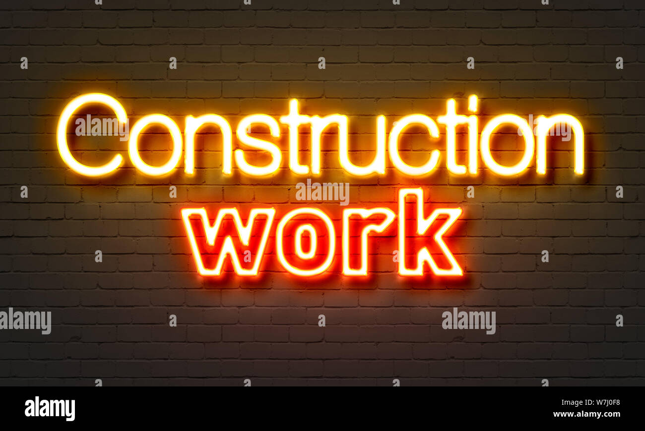 Construction work neon sign on brick wall background Stock Photo - Alamy