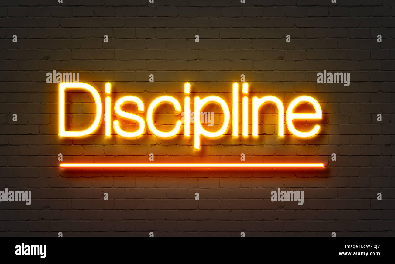 Discipline neon sign on brick wall background Stock Photo - Alamy