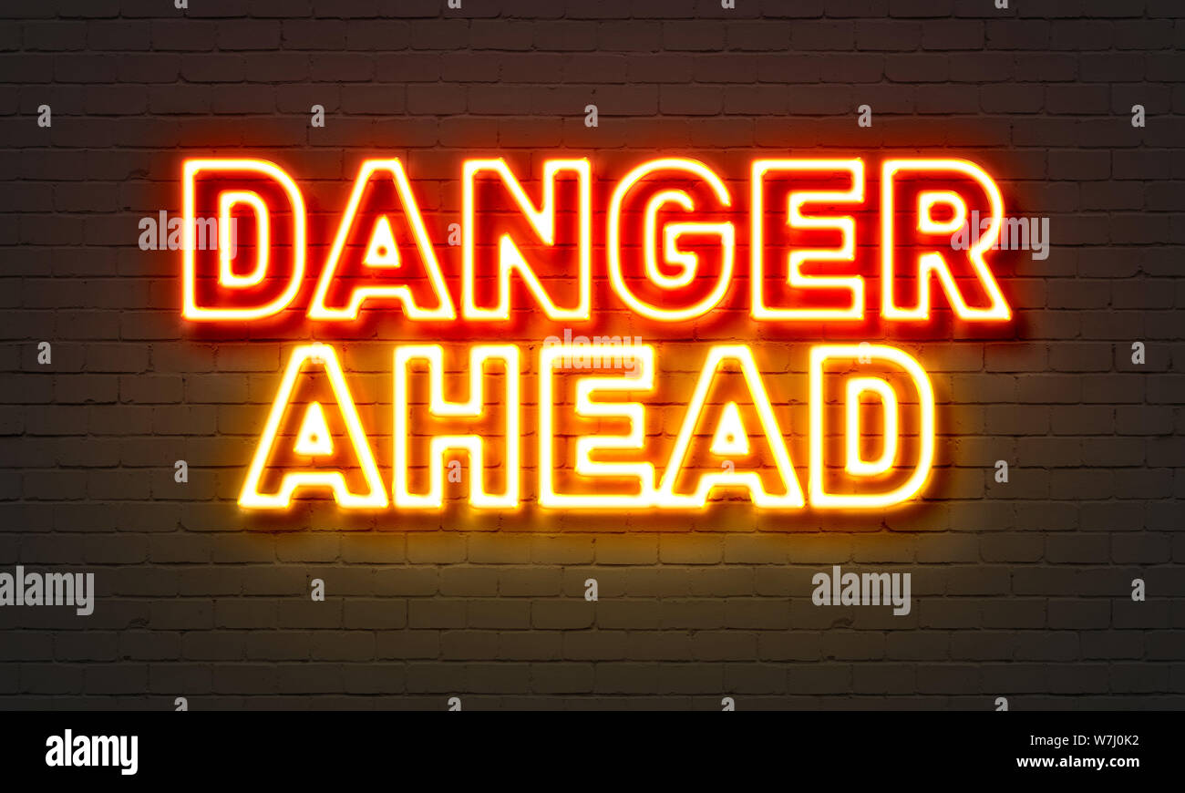 Danger ahead neon sign on brick wall background Stock Photo - Alamy