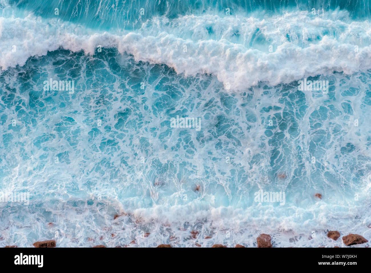 Top down view on waves at the shore Stock Photo - Alamy