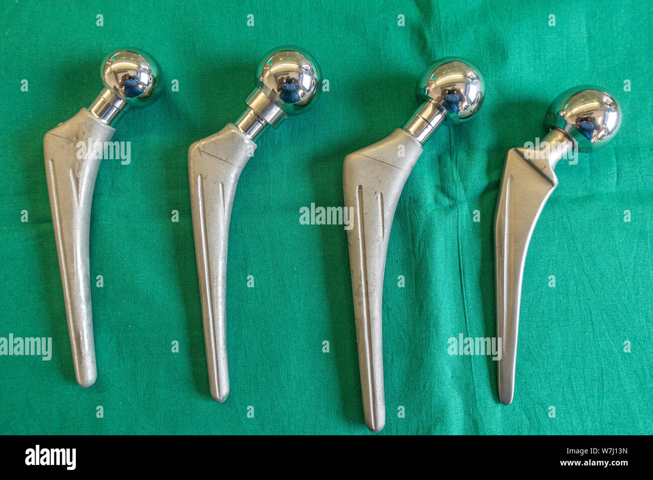 explanted hip prostheses lie spread out on a green surgical drape Stock ...