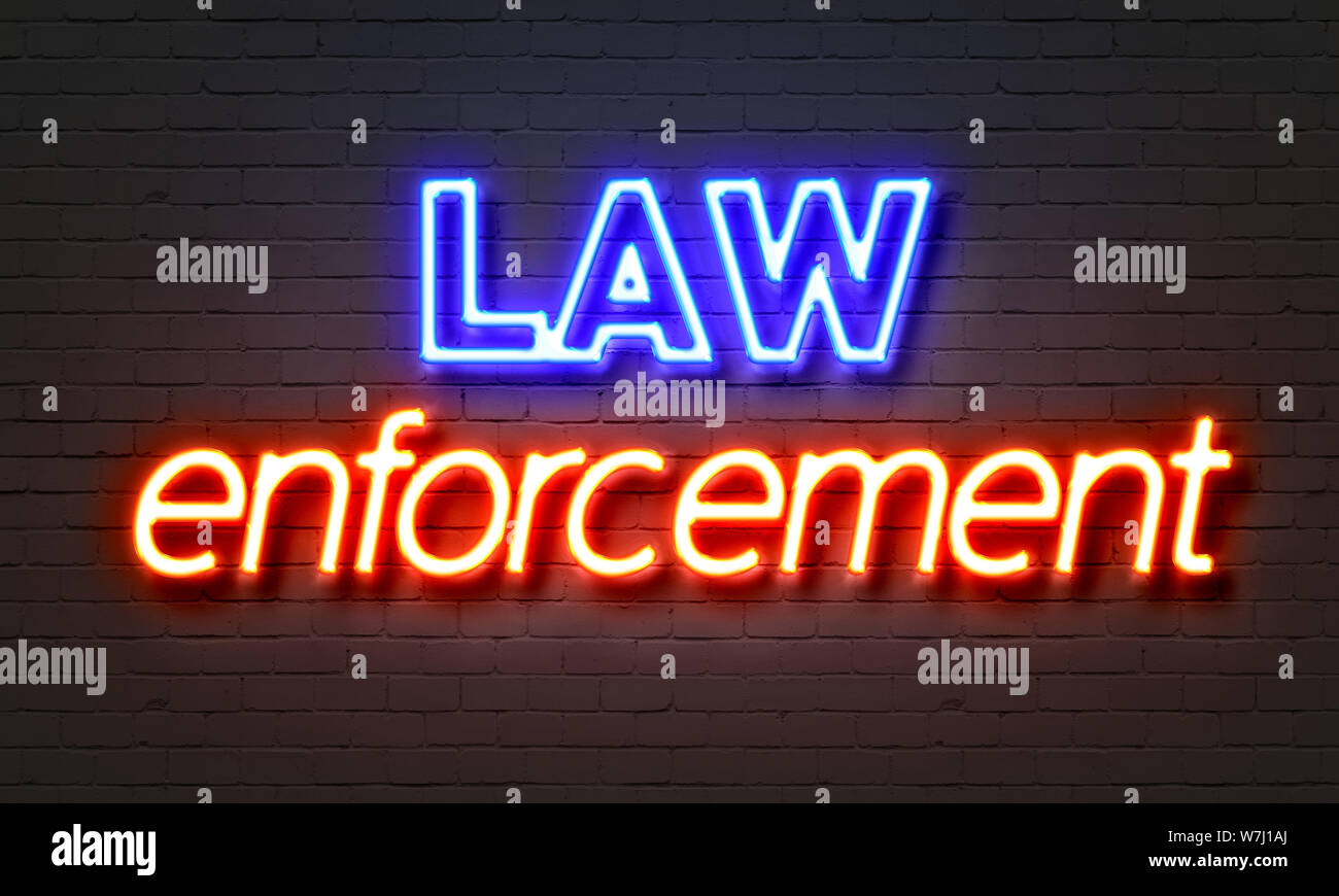 Law enforcement neon sign on brick wall background Stock Photo - Alamy
