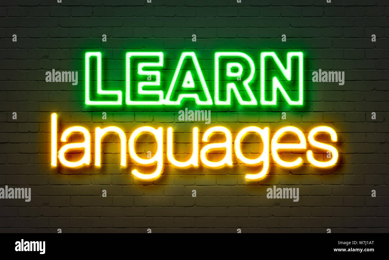 Learn languages neon sign on brick wall background Stock Photo - Alamy