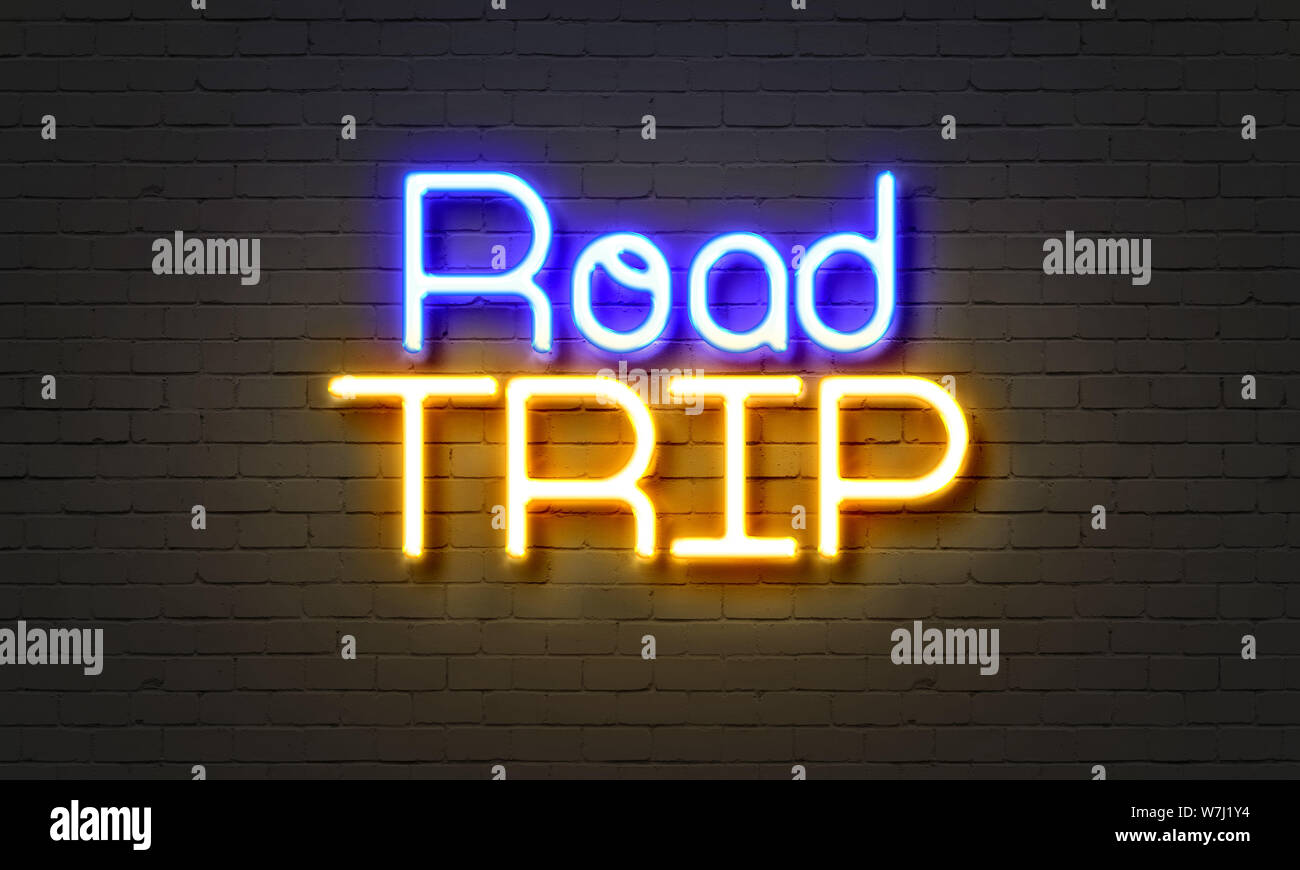 Road trip neon sign on brick wall background Stock Photo - Alamy