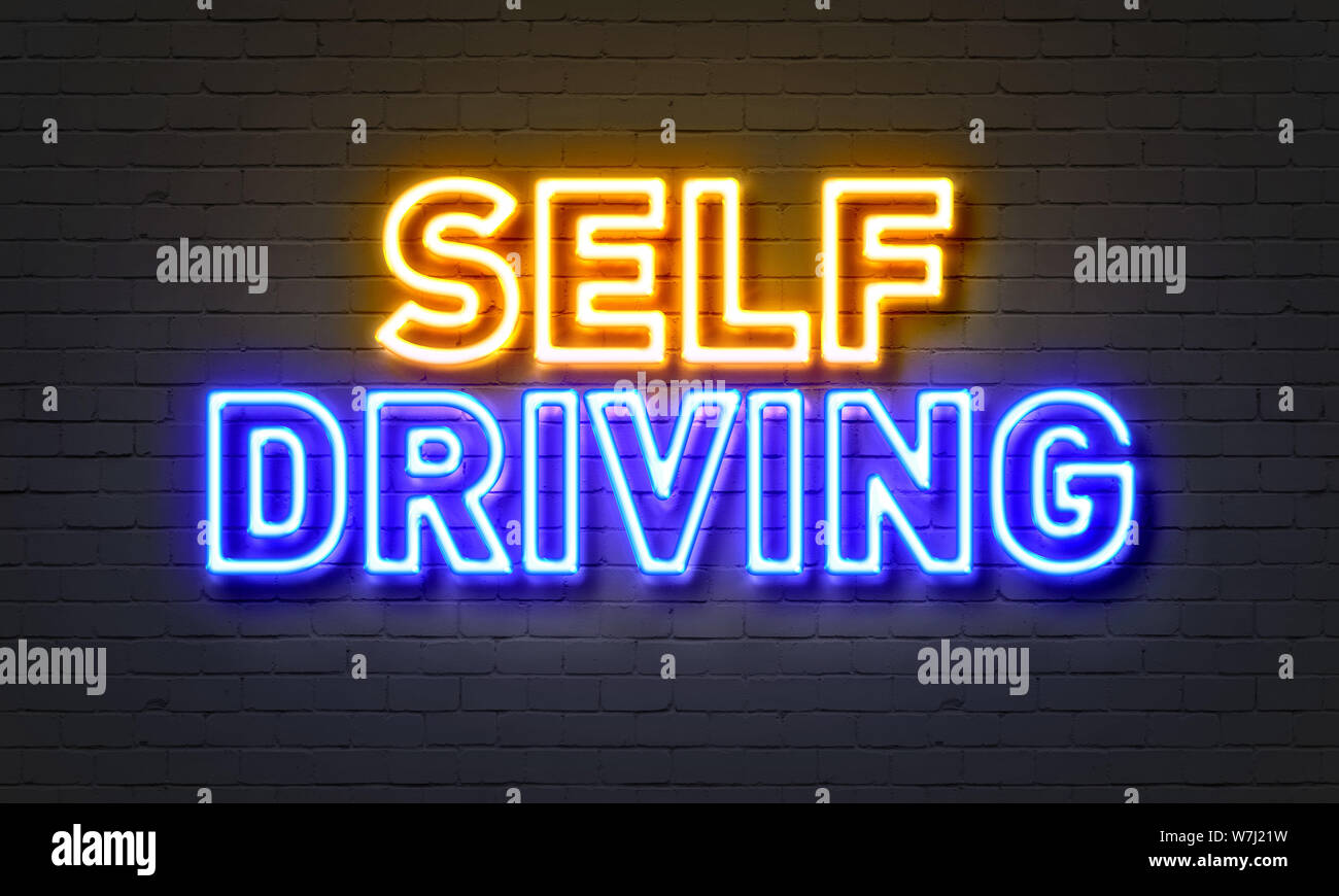 Self driving neon sign on brick wall background Stock Photo - Alamy