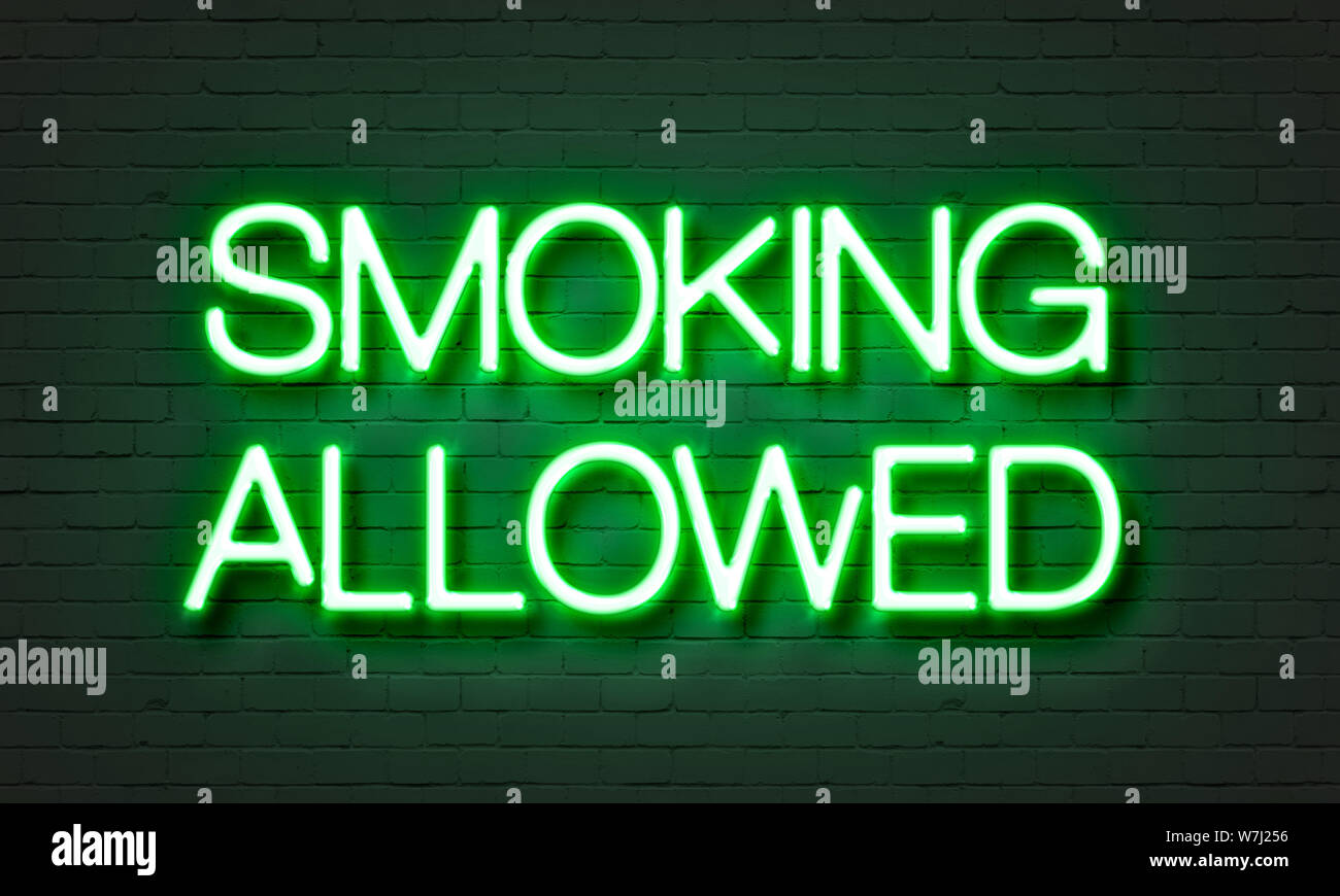 Smoking allowed neon sign on brick wall background Stock Photo - Alamy