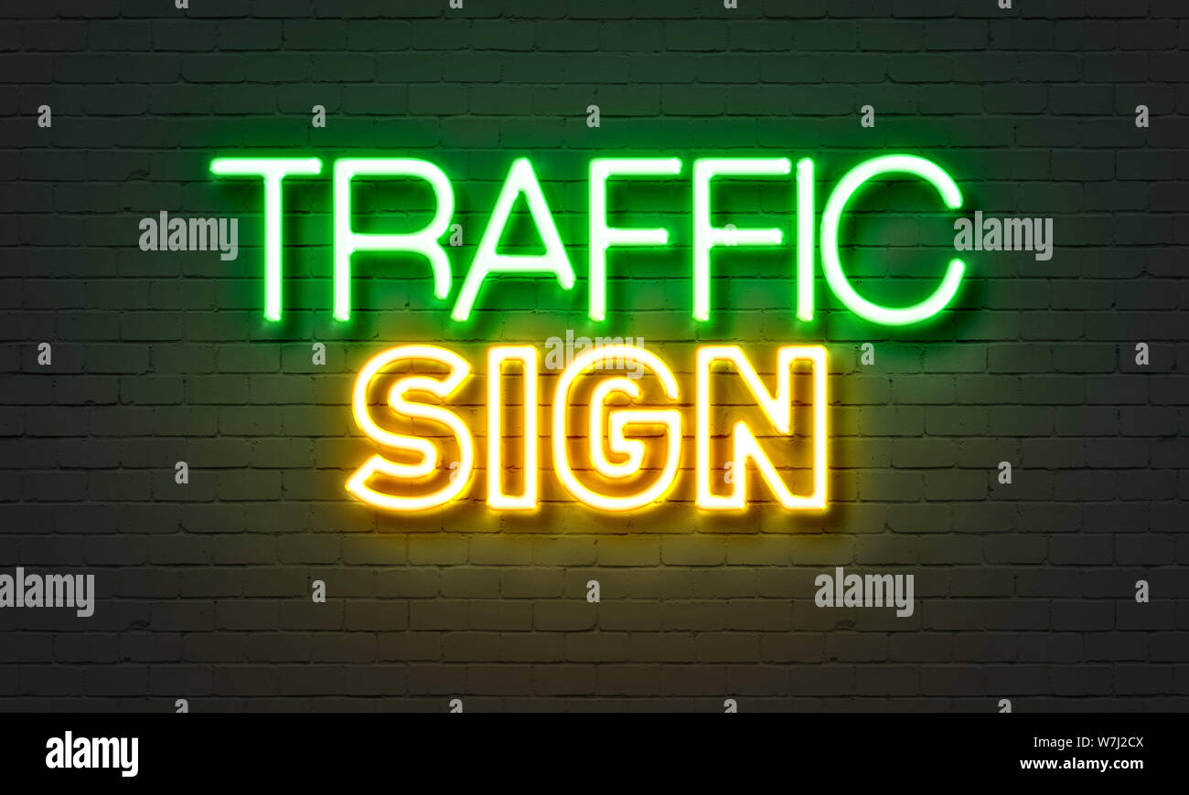 Traffic sign neon sign on brick wall background Stock Photo - Alamy