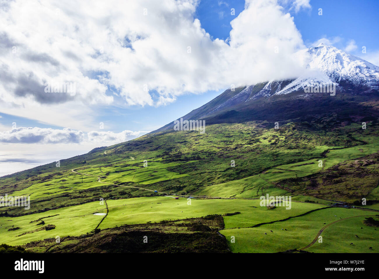 Mount Pico volcano summit and southern slope under blue sky and clouds ...