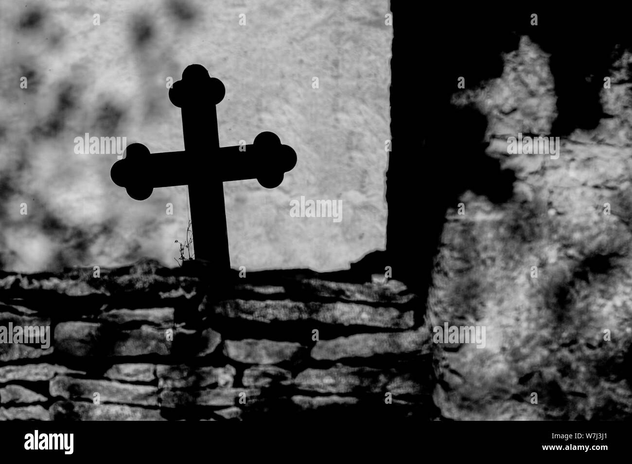 Cross over the masonry. Black and white gloomy photo Stock Photo - Alamy