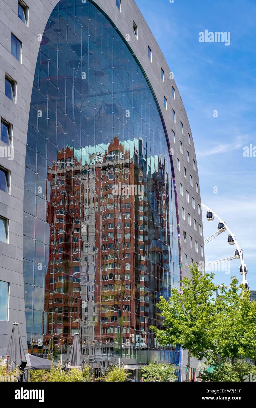 Statendam residential tower reflected in the glass facade of the market ...