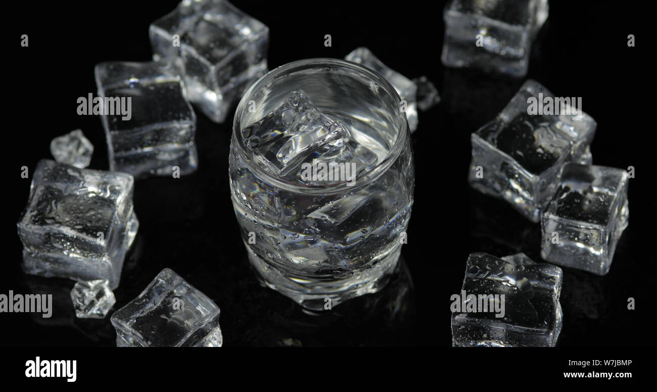 Shot of vodka with ice cubes against black background. Alcohol drink ...